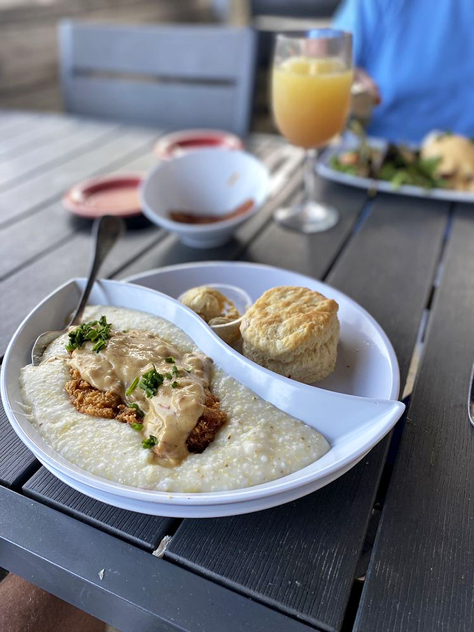 Southern comfort on a plate: creamy grits, fresh avocado, and a biscuit that would make your grandmother simultaneously proud and jealous. 