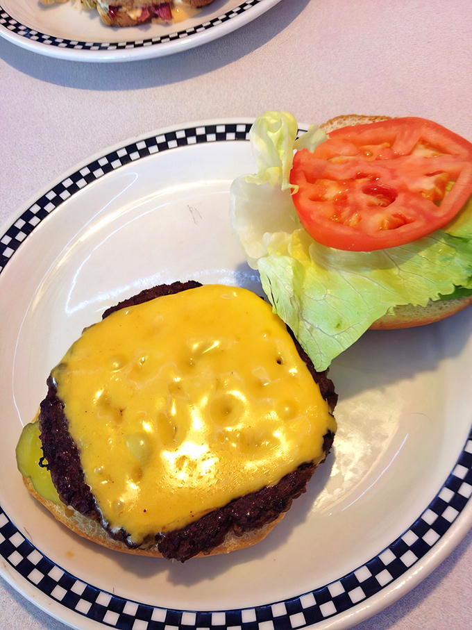 Behold the cheeseburger in its natural habitat &ndash; perfectly melted American cheese blanketing a hand-formed patty. Simple perfection on a plate.