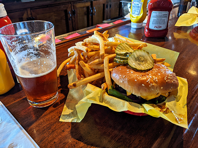 The perfect trifecta: a juicy cheeseburger, golden fries, and a cold beer. Some relationships are just meant to be, and this is burger destiny.