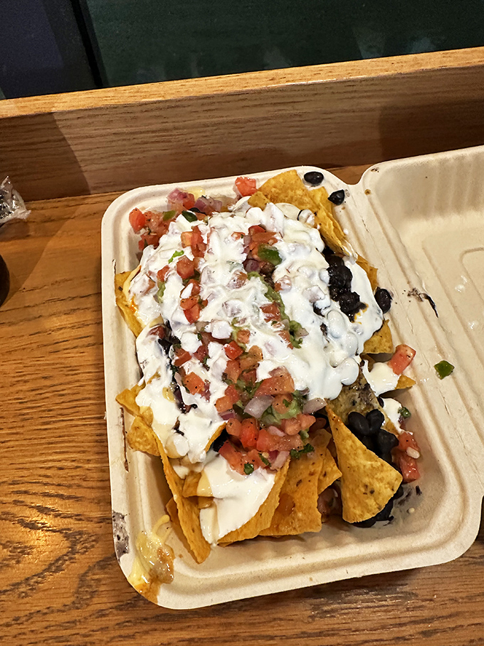 Behold the nacho mountain! Layers of chips, cheese, beans, and sour cream create a topographical map of flavor country.