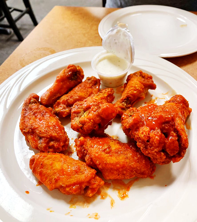 Wings that would make Buffalo proud, served in Orlando. That vibrant orange sauce isn't just showing off&mdash;it's delivering on its spicy promises.