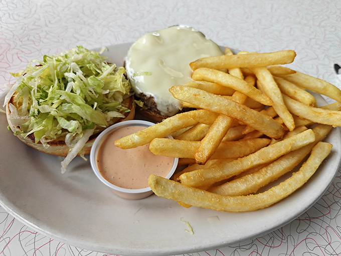 The holy trinity of diner perfection: golden fries, a properly dressed burger, and that special sauce that makes you contemplate licking the plate.