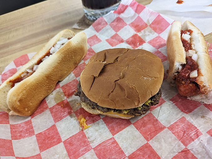 The holy trinity of Michigan roadside dining: a classic cheeseburger flanked by two coney dogs, all served on checkered paper&mdash;nature's perfect meal doesn't need fancy plating.