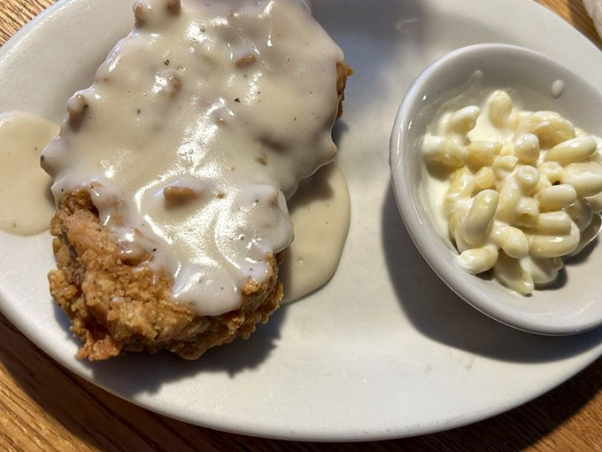 Country fried steak smothered in creamy gravy with a side of mac and cheese&mdash;comfort food that hugs your soul before it fills your stomach.