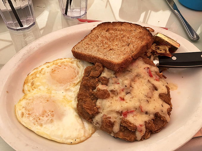 Country fried steak smothered in creamy gravy alongside perfectly cooked eggs. Comfort food that makes you want to hug your plate.