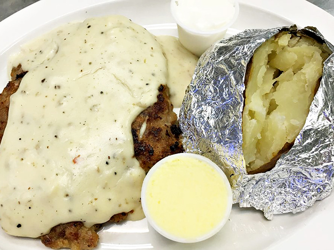 Country fried steak smothered in peppery gravy alongside a foil-wrapped potato&mdash;comfort food that doesn't need Instagram filters to look absolutely magnificent.