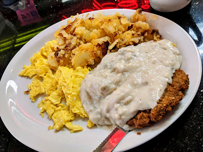 Country fried steak smothered in gravy alongside sunny scrambled eggs and crispy potatoes&mdash;the breakfast trifecta that makes mornings worthwhile.