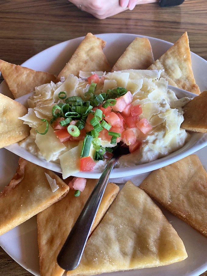 The crab dip arrives surrounded by crispy triangles of fried pita, like a royal court attending to seafood royalty. One bite explains why it's legendary.