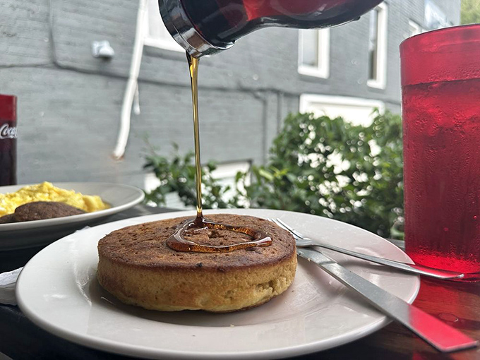 Syrup cascades down the side of pancake perfection. Some people travel hundreds of miles just for this moment of breakfast bliss.