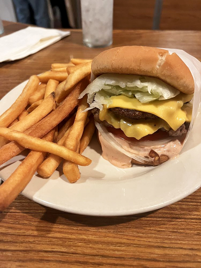 The holy trinity of diner perfection: a double cheeseburger with perfectly golden fries and that special sauce that haunts your dreams.