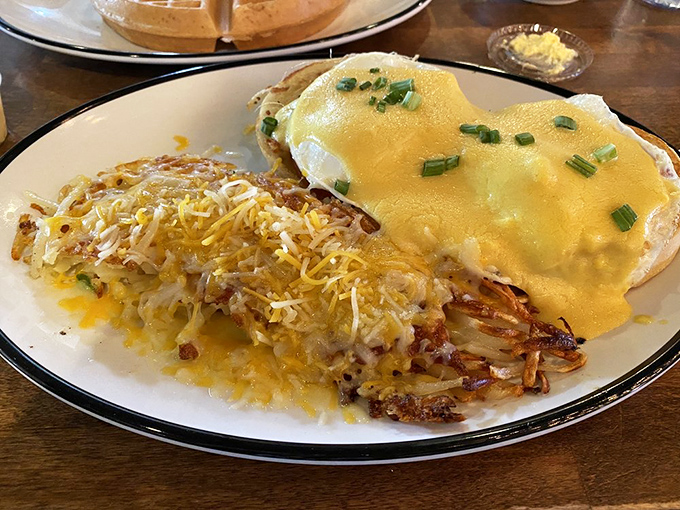 Eggs Benedict with crispy hashbrowns&mdash;where hollandaise sauce cascades down like a yellow waterfall of buttery goodness that dreams are made of.