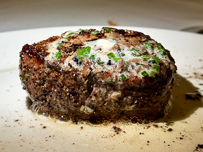 The filet mignon sits majestically on its white throne, wearing a crown of butter and herbs like it knows exactly how good it is.