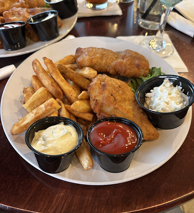 Golden-battered fish that shatters with each bite, accompanied by chips that achieve the perfect balance between crisp exterior and fluffy interior.