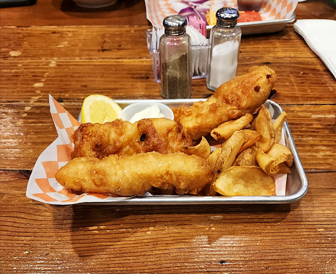 Fish and chips served on a metal tray&mdash;because some traditions are too perfect to mess with. That tartar sauce is calling your name.