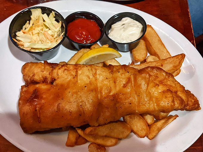 Fish and chips done proper &ndash; crispy exterior giving way to flaky white fish, with tangy coleslaw providing that perfect counterpoint. God save the cuisine!