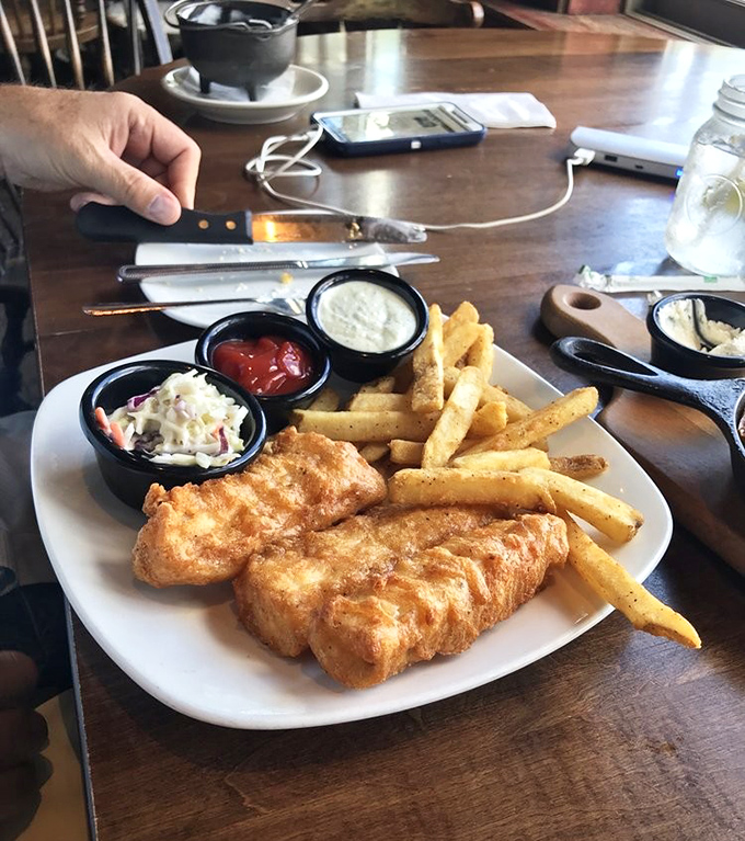 The perfect trio: golden fish, crispy fries, and fresh coleslaw. Like a culinary boyband where every member pulls their weight.