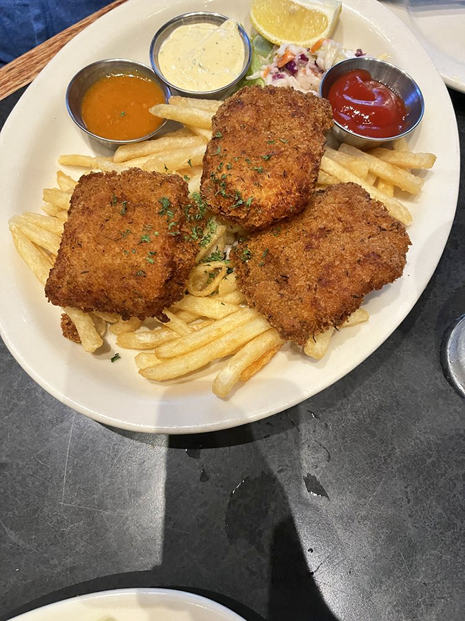 Three perfectly fried fish fillets standing at attention, ready to be dunked in an array of sauces. This isn't just fish and chips&mdash;it's an edible art installation.
