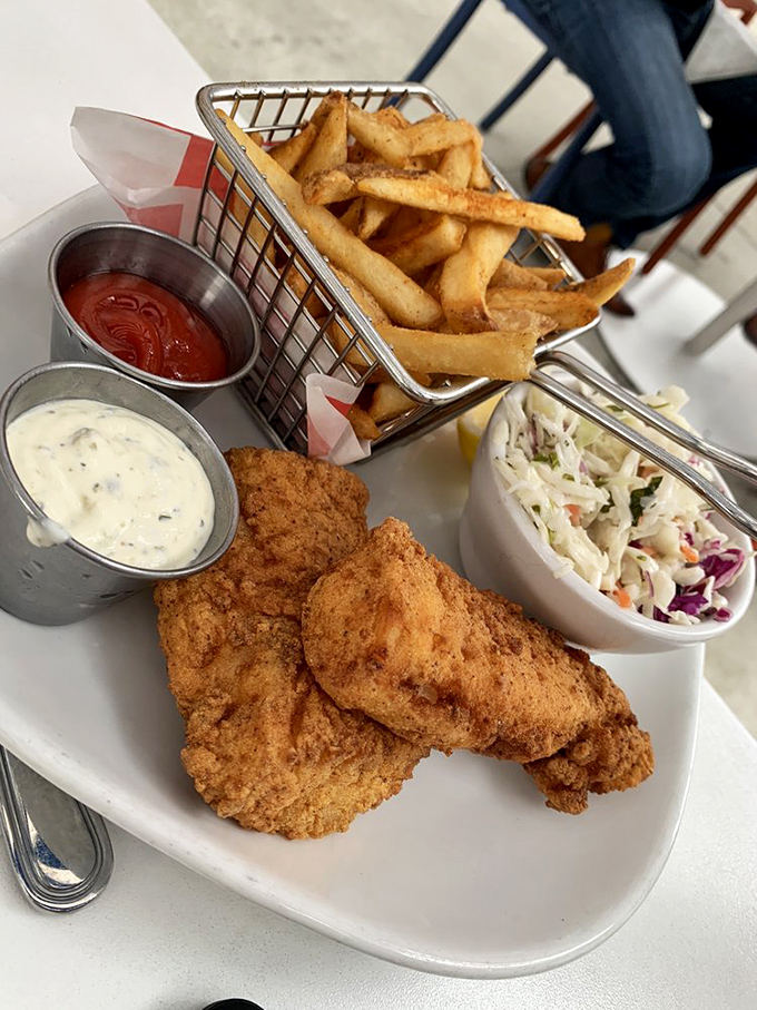 The fish and chips arrive like edible architecture&mdash;crispy battered fish perched beside a wire basket of fries, with house-made slaw providing the perfect counterpoint.