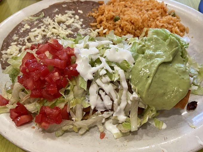 A plate that tells a story of balance &ndash; rice, beans, guacamole, and sour cream creating the perfect supporting cast for the main attraction.