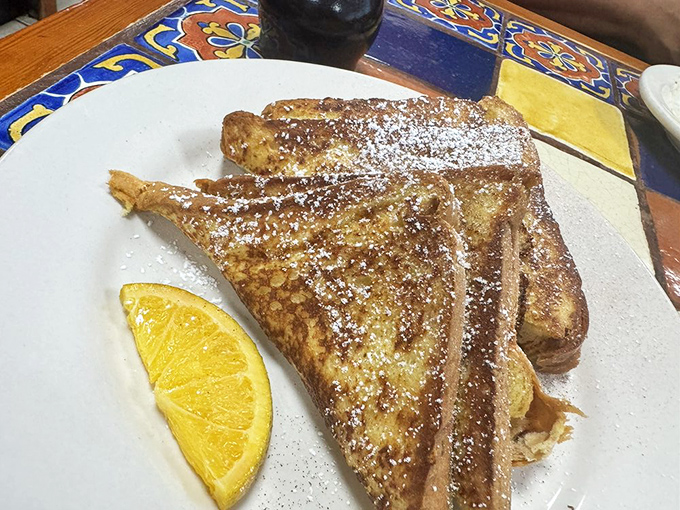 French toast dusted with powdered sugar and served with a citrus smile – breakfast's way of saying "today might actually be worth getting up for."