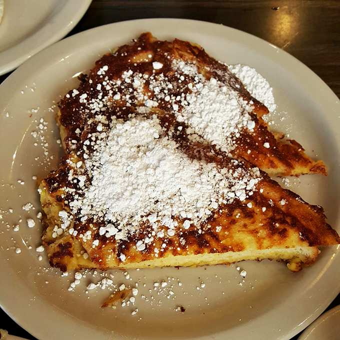 French toast that's achieved the golden ratio: crispy exterior, custardy interior, and a snowfall of powdered sugar that makes every bite Instagram-worthy.