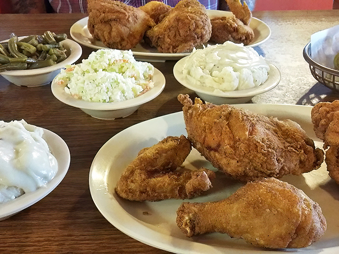 A family-style feast where the fried chicken takes center stage, surrounded by supporting actors of coleslaw, mashed potatoes, and green beans.