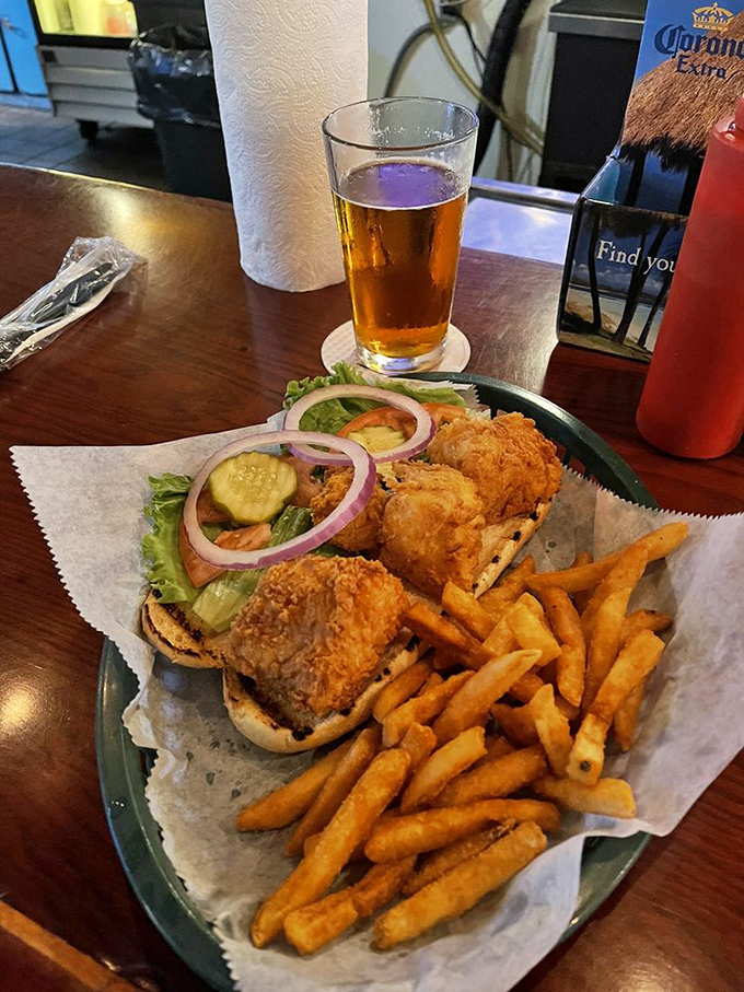 The perfect marriage: cold beer meets crispy sandwich. This golden-fried masterpiece demands both hands and zero distractions.