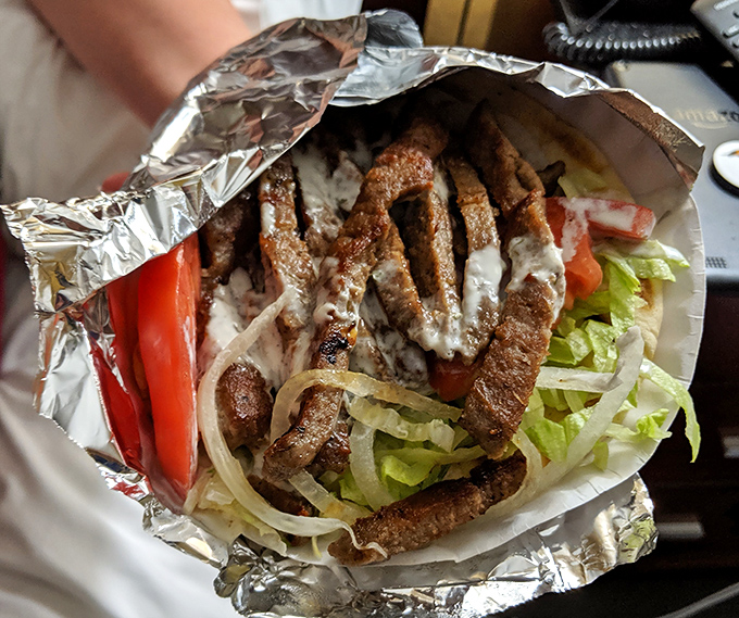 A perfect gyro wrapped in foil like a savory present&mdash;juicy meat, fresh veggies, and sauce that makes you forget you came for chicken.