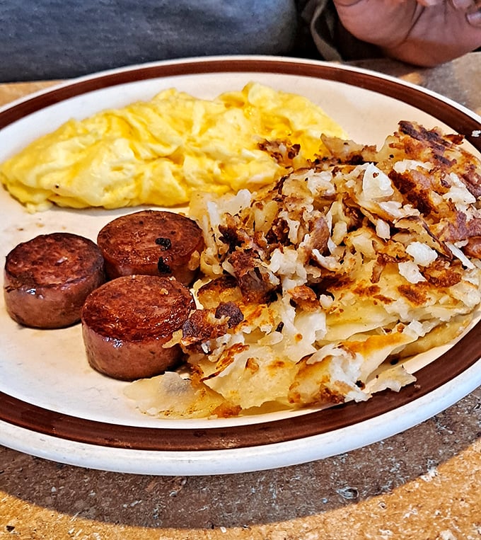 Breakfast perfection on a plate: fluffy scrambled eggs, crispy-edged hashbrowns, and sausage patties with that perfect sear. The breakfast trinity that never disappoints.