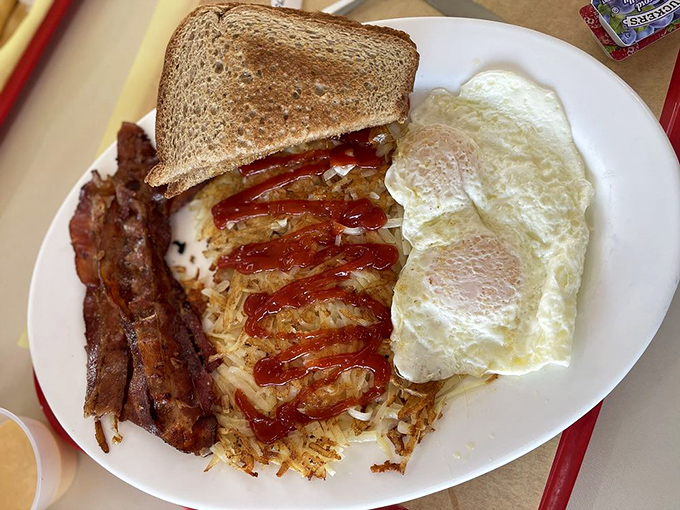 Breakfast nirvana: crispy hash browns, perfectly cooked eggs, and toast ready to soak up every last bit of yolk. Morning salvation on a plate.