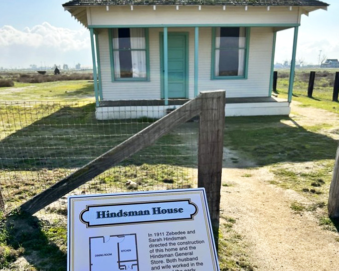 The Hindsman House stands as a testament to early 20th century optimism, its mint-green trim a cheerful accent against the golden landscape.