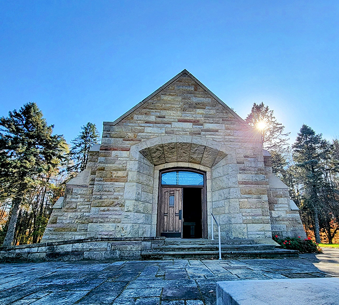 The Memorial Chapel stands as a peaceful stone sanctuary amid the forest. Sunlight filters through stained glass, creating a moment of tranquility in nature's embrace.