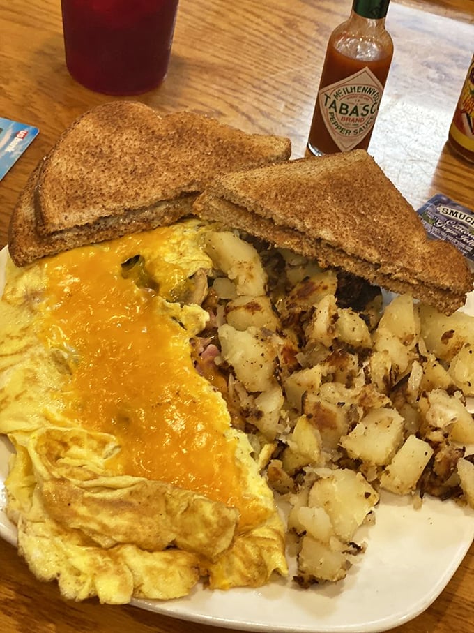 The perfect marriage: a cheese-draped omelet that practically winks at you, alongside home fries with that ideal crisp-to-fluffy ratio.