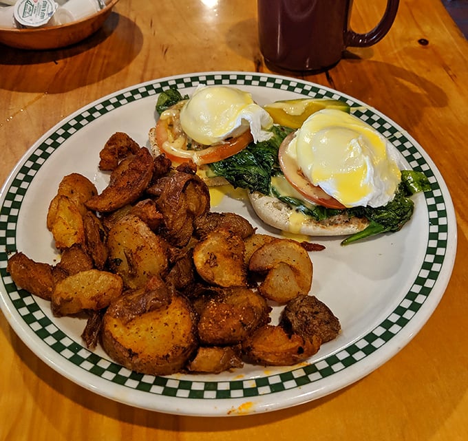 Benedict done right—perfectly poached eggs perch atop English muffins while home fries stand by, ready for their supporting role in this breakfast drama.