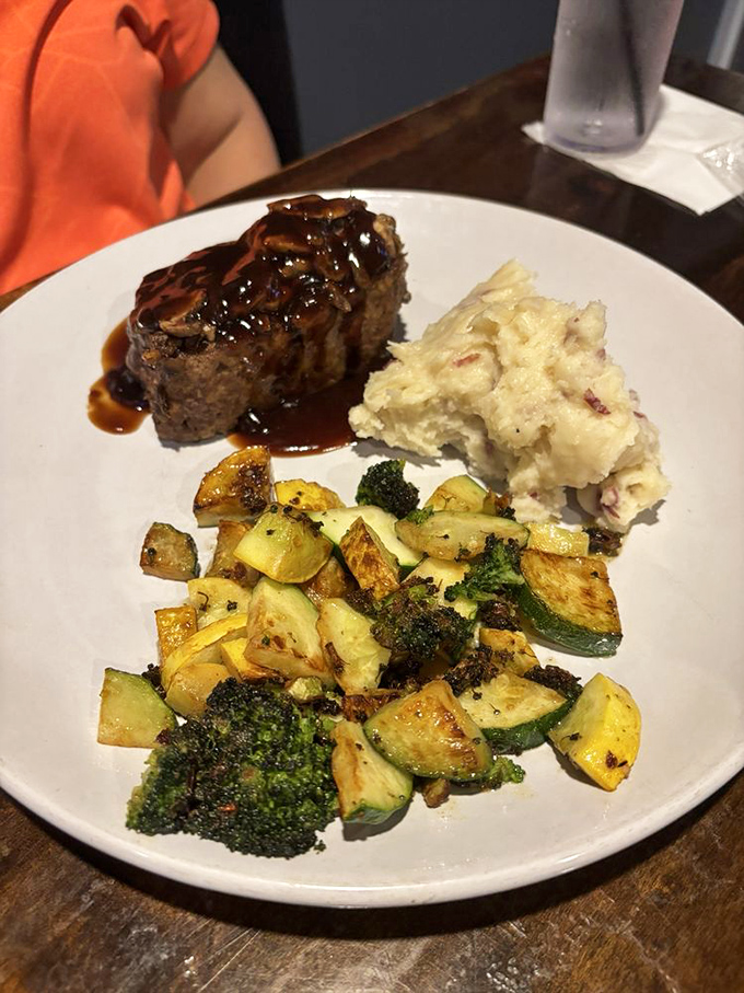 The holy trinity of dining: perfectly glazed meatloaf, red-skin mashed potatoes, and seasoned vegetables that weren't just an afterthought.