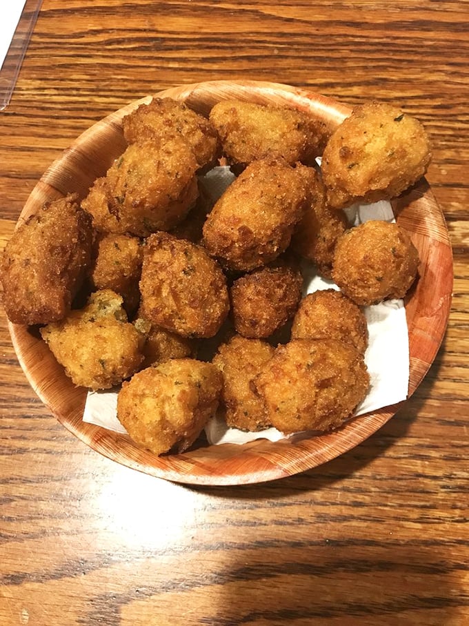 These golden hushpuppies aren't just side dishes; they're little cornmeal treasures that might upstage your main course if you're not careful.