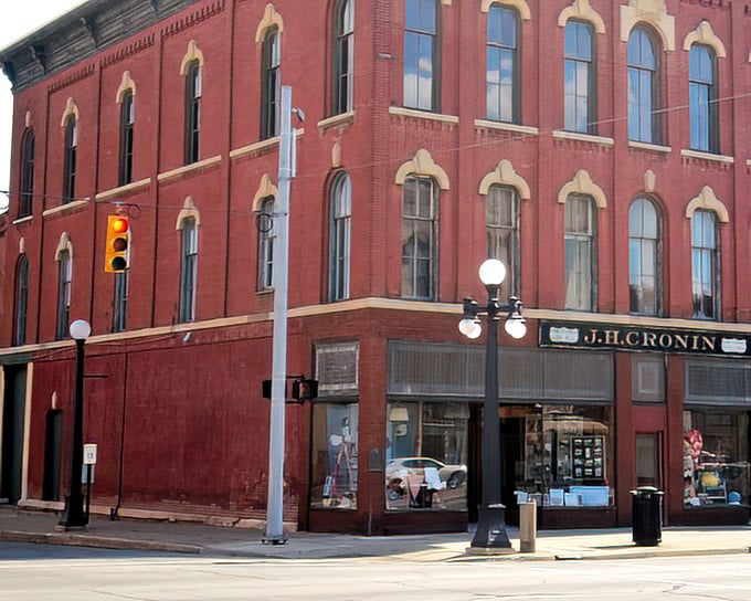 The magnificent red brick J.H. Cronin Building anchors the corner with the quiet confidence of someone who knows they've aged better than most of us ever will.