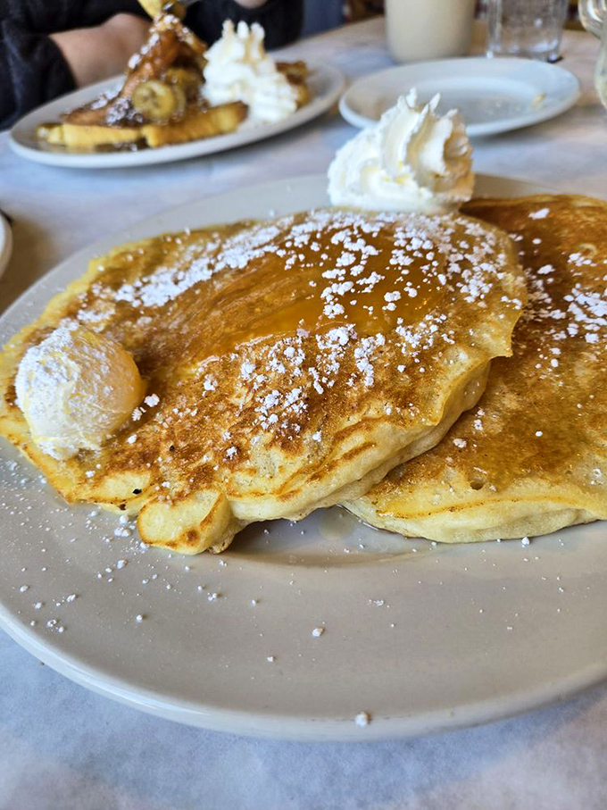 Golden pancakes dusted with powdered sugar that make you wonder why anyone bothers with ordinary breakfast when this exists.