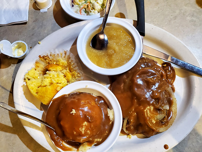 Comfort on a plate: tender liver smothered in caramelized onions alongside golden cornbread&mdash;a dish that makes you understand why grandparents get misty-eyed about diner food.