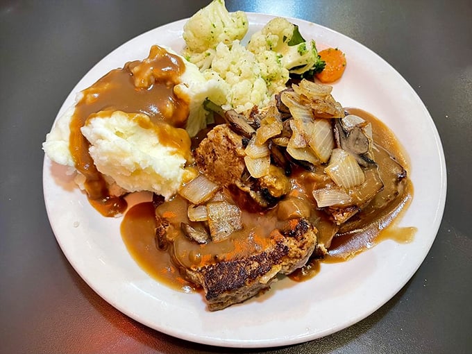 Meatloaf that could make a vegetarian question their life choices, topped with caramelized onions and gravy that deserves its own fan club.