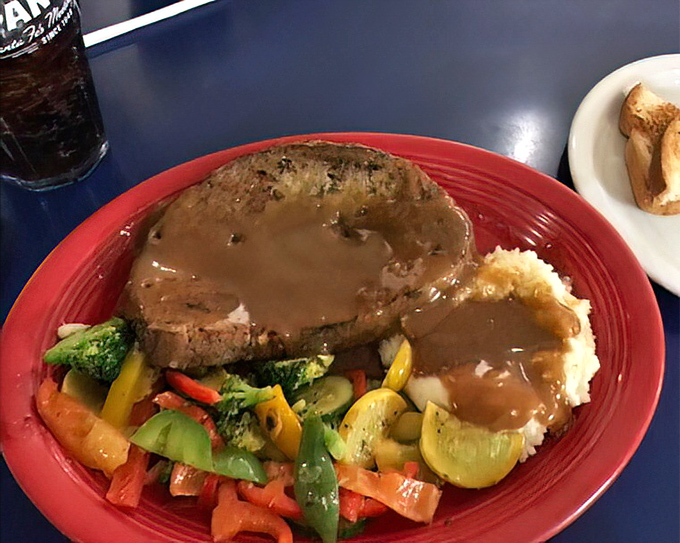 The holy trinity of comfort food: meatloaf, mashed potatoes, and colorful vegetables, all bathed in gravy that could make a vegetarian reconsider their life choices.