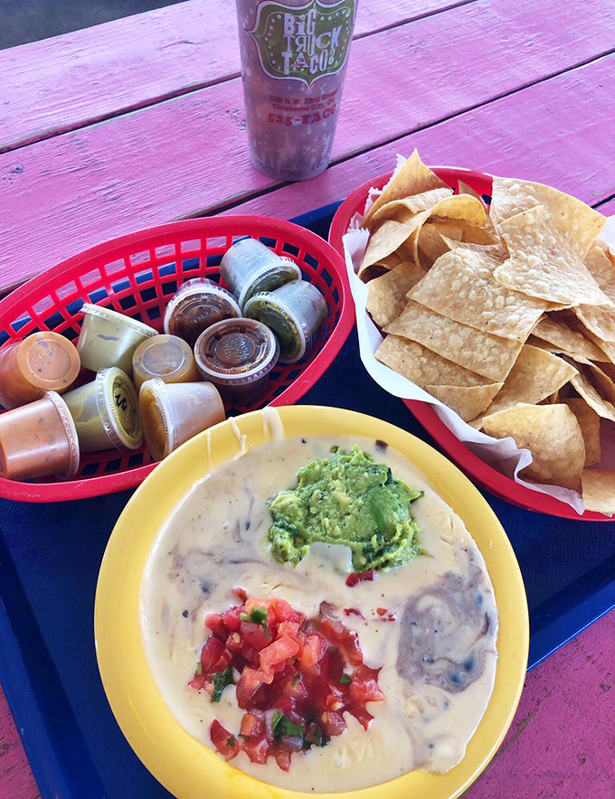 The holy trinity of taco accompaniments: house-made chips, a rainbow of salsas, and queso that demands to be photographed before consumption.
