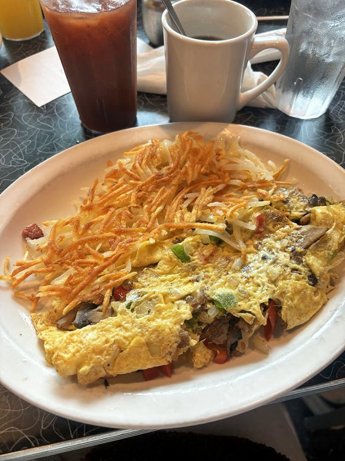 This isn't just an omelet&mdash;it's an architectural marvel of eggs, veggies, and cheese with a golden hash brown fortress standing guard.