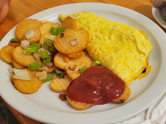 An omelette that defies gravity, paired with home fries that have achieved that mythical balance of crispy exterior and pillowy interior. Breakfast nirvana exists!