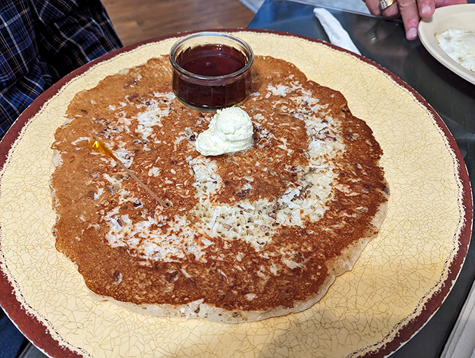 This pancake stretches to the edges of possibility, with a puddle of maple syrup standing by for its grand entrance.
