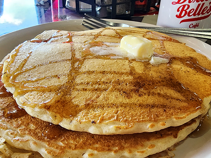 Pancakes so perfectly golden they belong in Fort Knox. That melting butter creating its own little syrup river? Pure breakfast poetry.