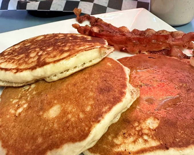 These golden pancakes aren't just breakfast, they're an edible sunrise with a side of perfectly crisp bacon standing at attention.
