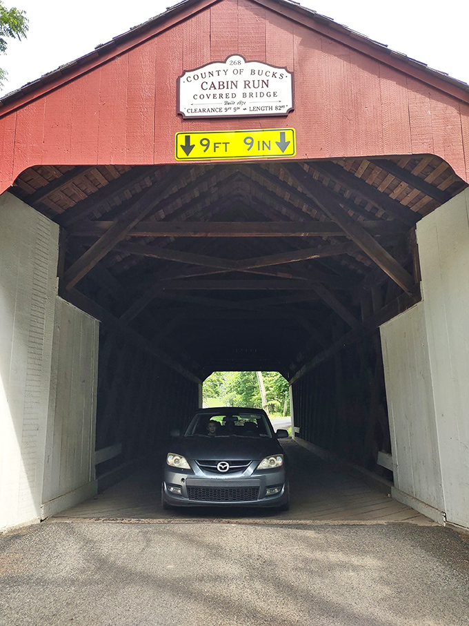 Modern meets historic as a car navigates through the wooden tunnel. Some things never change&mdash;like ducking your head when someone says "low clearance." 