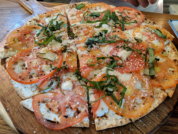 This isn't just pizza – it's a masterclass in balance. Fresh tomatoes, melted cheese, and basil ribbons create edible artwork that tastes even better than it looks.