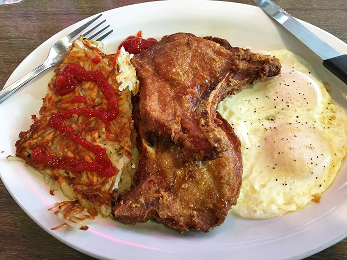 This isn't just breakfast&mdash;it's armor for the day ahead. That pork chop means business, and those hash browns are its willing accomplices.